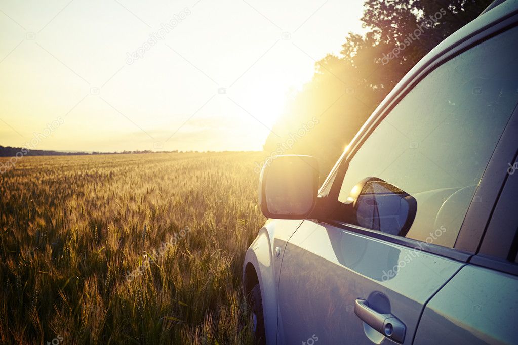 Car in the field on background of magnificent sunset Stock Photo by ...
