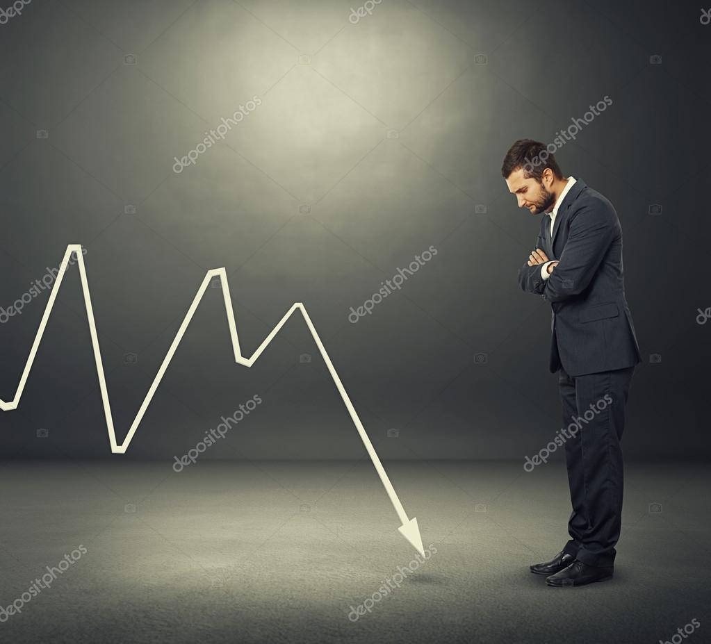 Man looking at negative graph Stock Photo by ©konstantynov 57773345