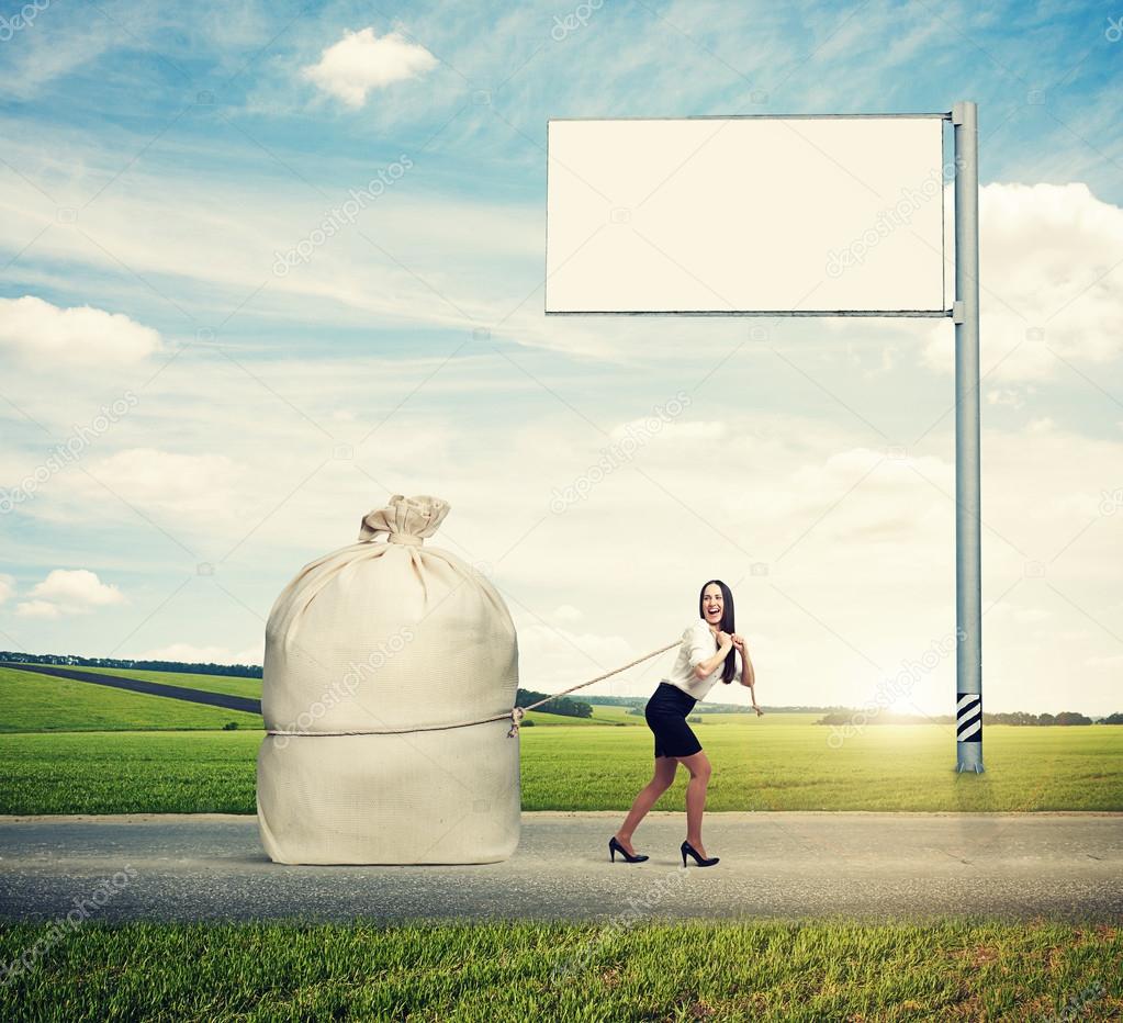 Laughing woman pulling big bag Stock Photo by ©konstantynov 78567596