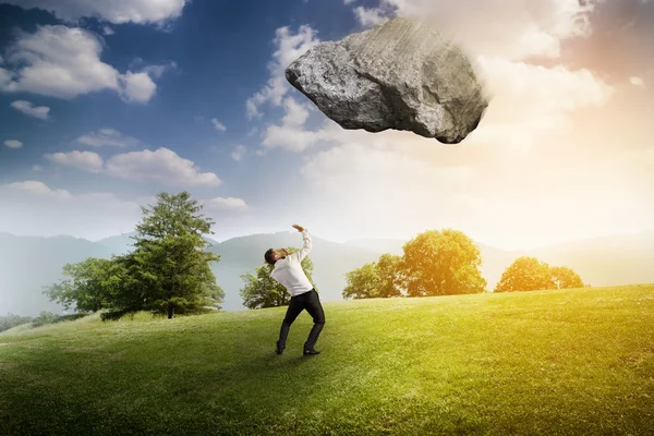 Big stone falling down on scared businessman Stock Photo by ...