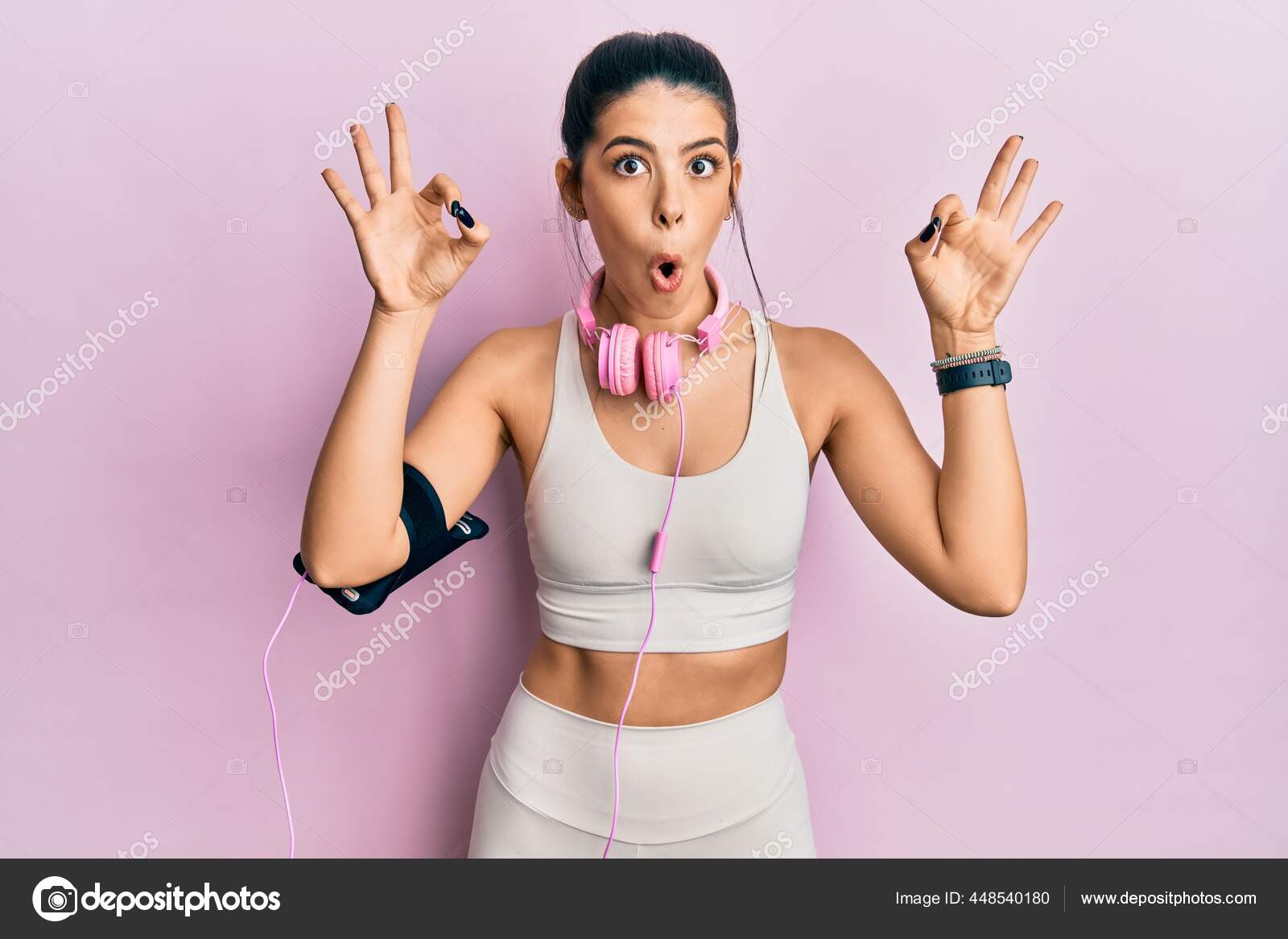 Young Hispanic Woman Wearing Gym Clothes Using Headphones Looking ...