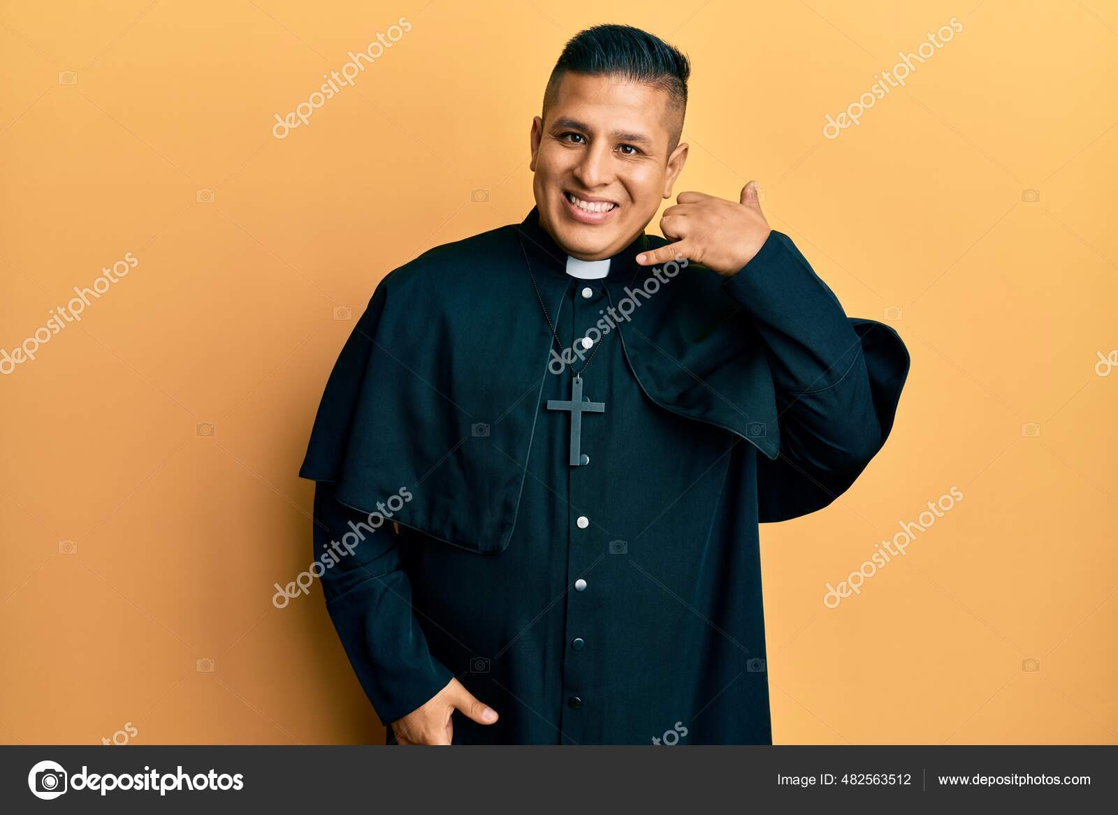 Young Latin Priest Man Standing Yellow Background Smiling Doing Phone ...