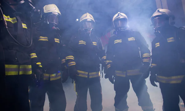 Portrait of group of firefighters in the middle of the smoke of the ...