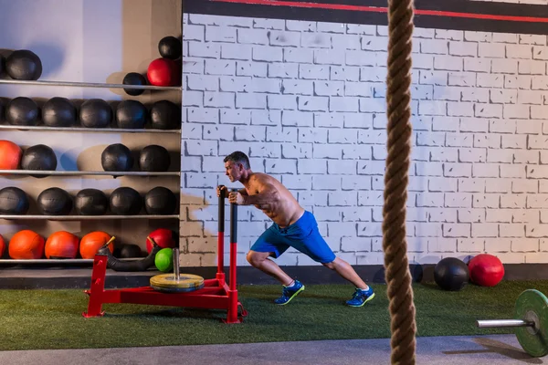 Sled push man pushing weights workout - Stock Image - Everypixel