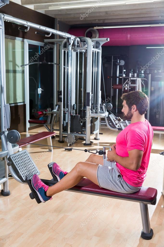 Seated cable row man rows at gym pulley machine Stock Photo by ...