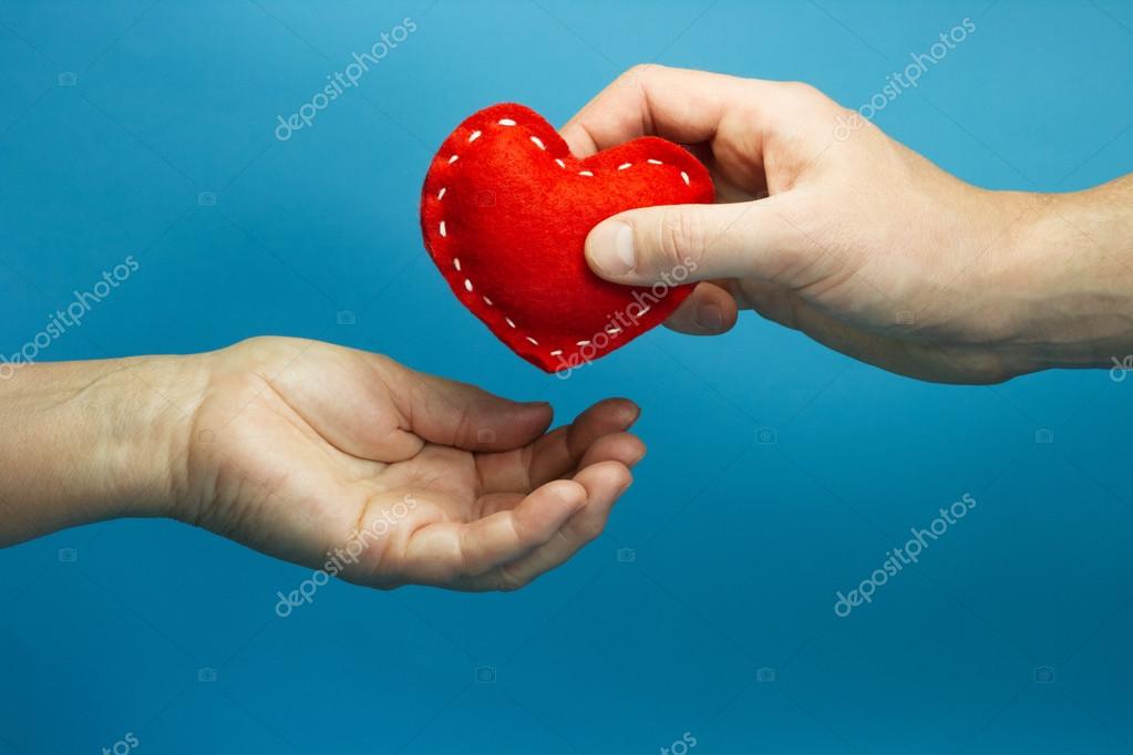 mano poniendo el corazón en la mano de la mujer 2023