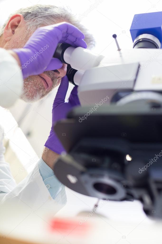 Senior scientist microscoping in lab. Stock Photo by ©kasto 92200104
