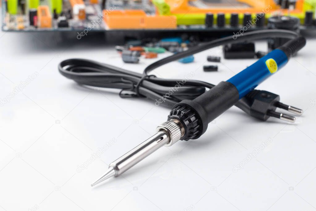 soldador en el fondo de una placa de ordenador y condensadores en enfoque suave. El concepto de ...