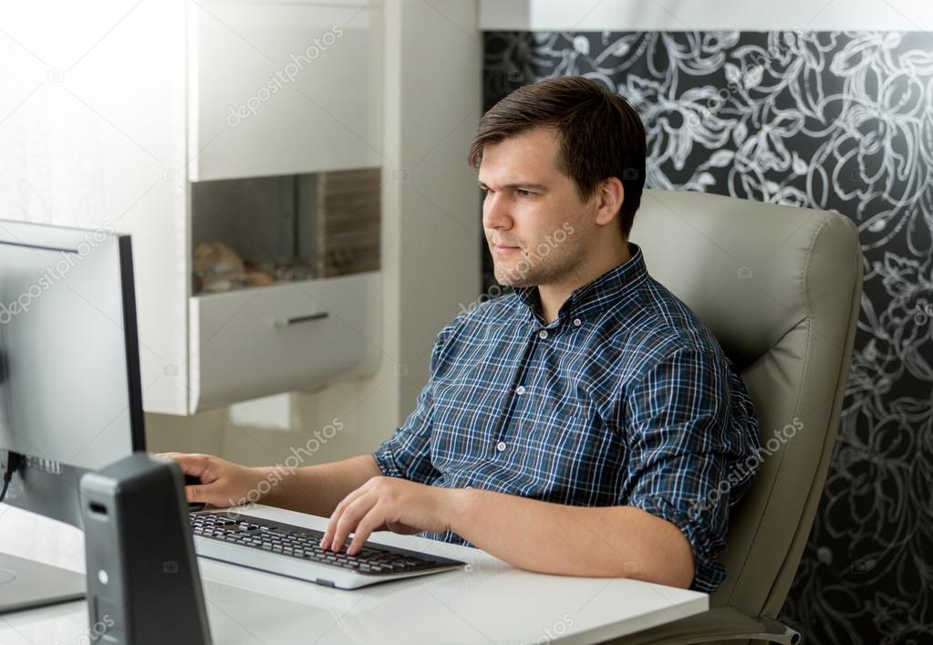 Portrait of concentrated man working on computer at home office Stock ...