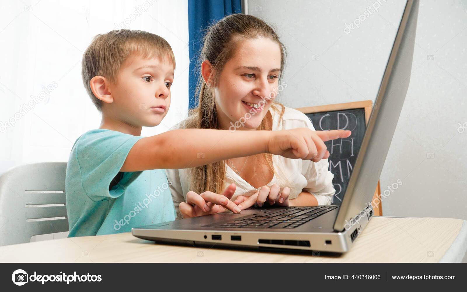 Amazed little boy pointing with finger in laptop screen. Amazed child ...