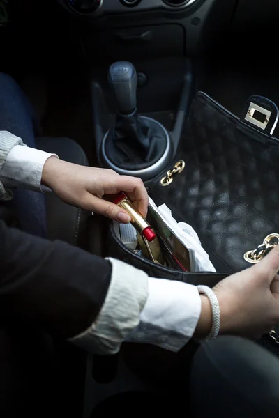Woman searching for things in black handbag - Stock Image - Everypixel