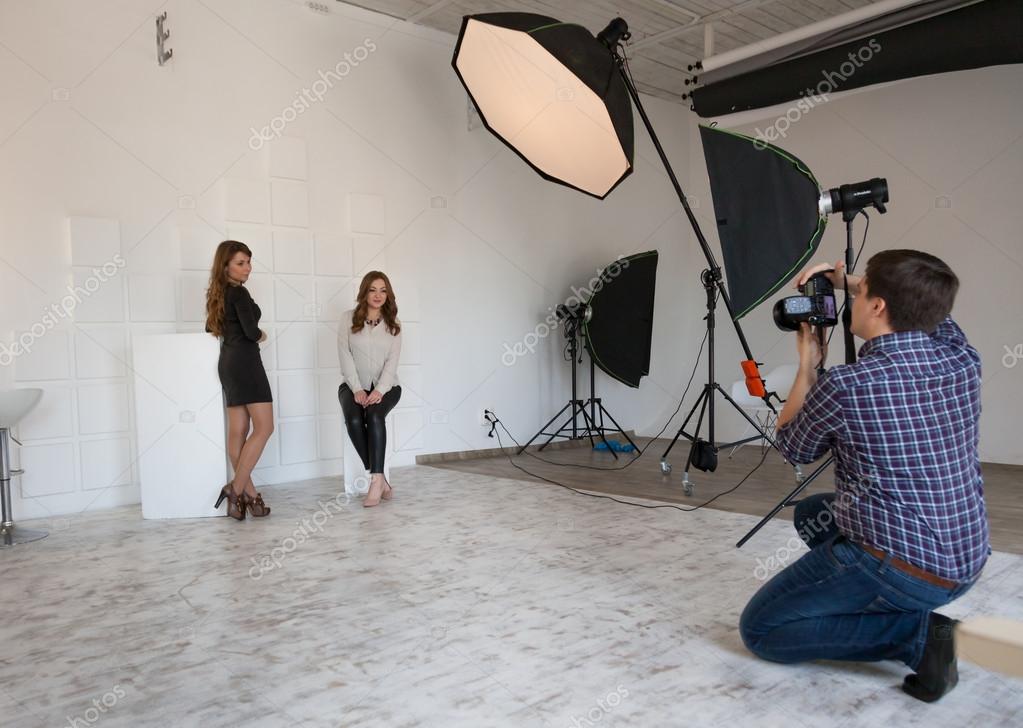 Professional photographer at studio with female models — Stock Photo ...
