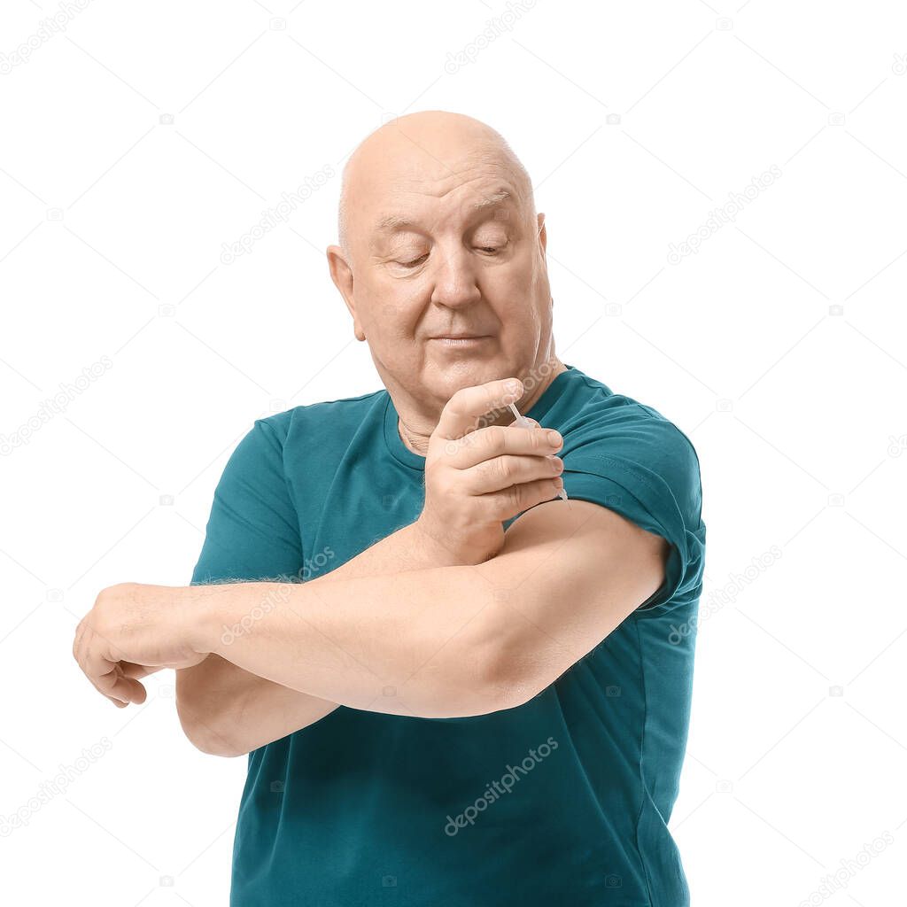 Hombre diabético mayor inyectándose insulina sobre fondo blanco 2024