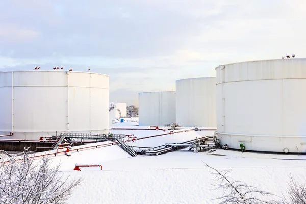 White tanks in tank farm with snow in winter - Stock Image - Everypixel