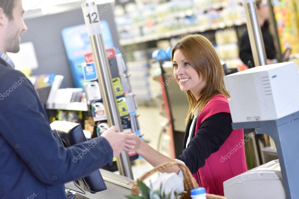 Cashier with customer paying — Stock Photo © Goodluz #101392992