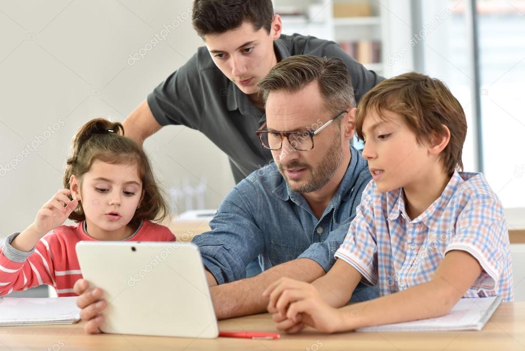 Teacher with students using digital tablet Stock Photo by ©Goodluz ...