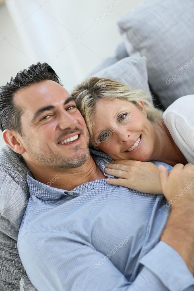 Mature couple relaxing in sofa Stock Photo by ©Goodluz 58087819
