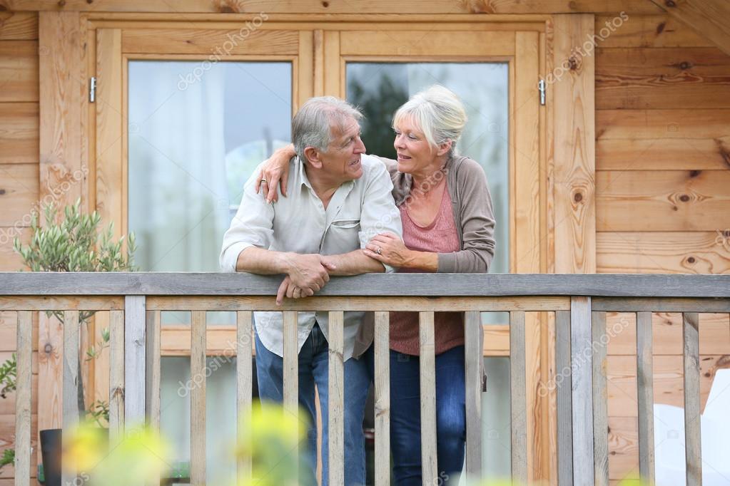 Couple standing oustide log cabin — Stock Photo © Goodluz #58089455