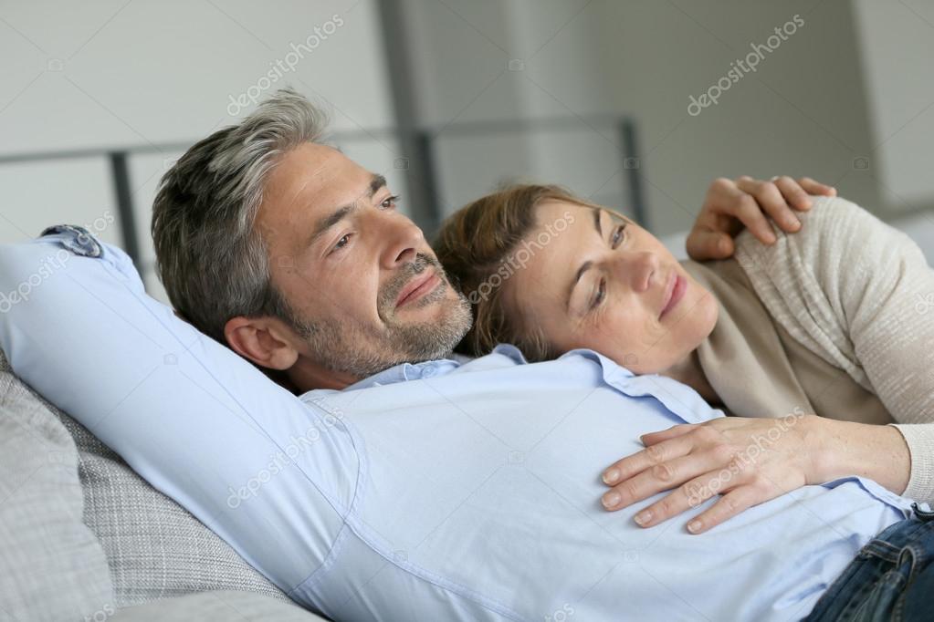 Mature couple relaxing on sofa — Stock Photo © Goodluz #70977425