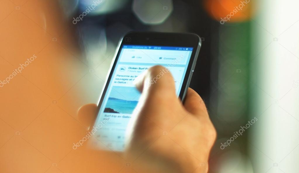 Man uses facebook app on smartphone — Stock Editorial Photo © aa-w ...