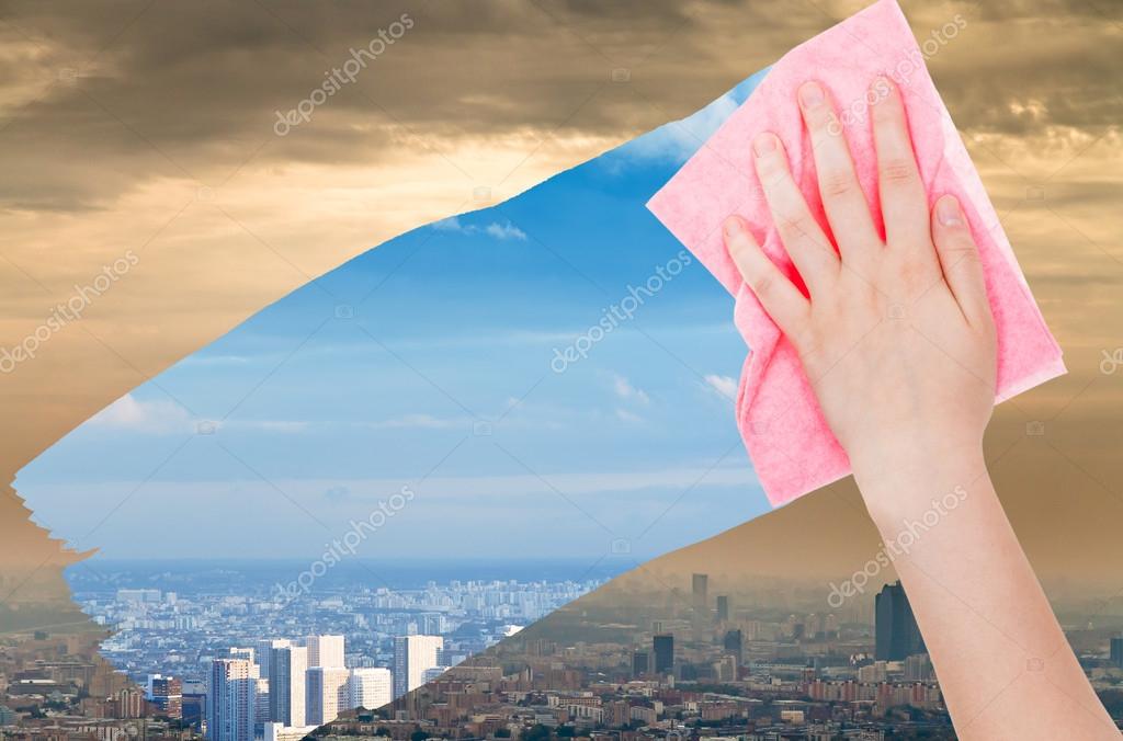 Hand deletes smog in city by pink cloth — Stock Photo © vvoennyy #79414752