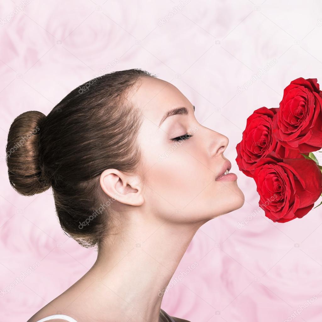 Attractive young woman smelling roses Stock Photo by ©kotin 110033456