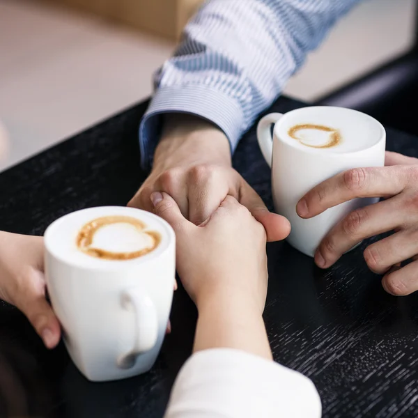 Handsome man drinking coffee at in cafe. Grooms hands holding cup of ...