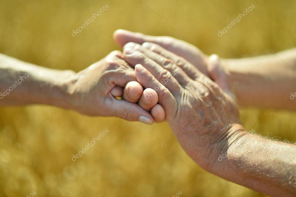 Elderly couple holding hands Stock Photo by ©aletia 93211684
