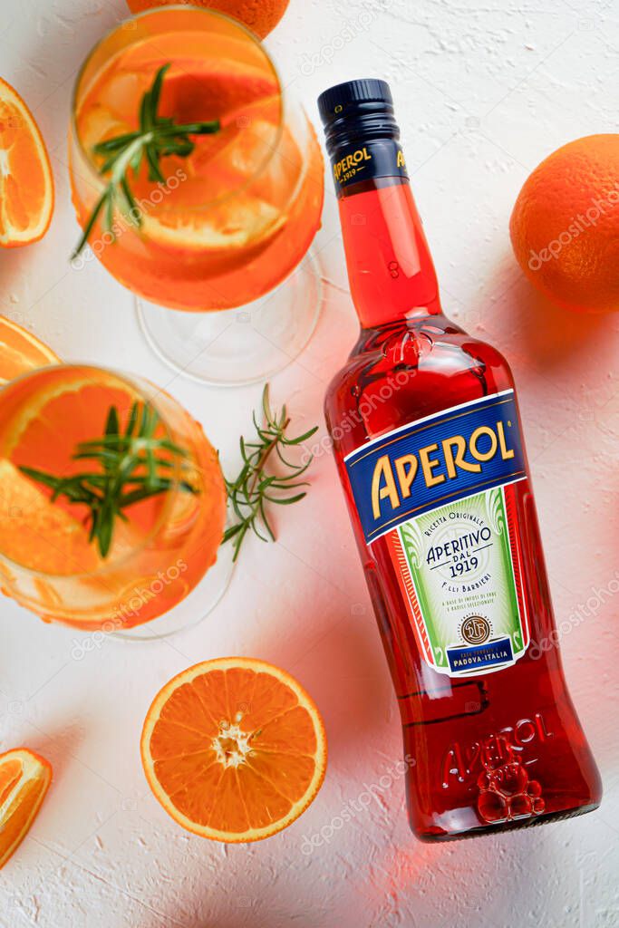Tintura italiana Aperol para hacer cóctel Aperol Spitz. Vino tinto-naranja en una botella ...
