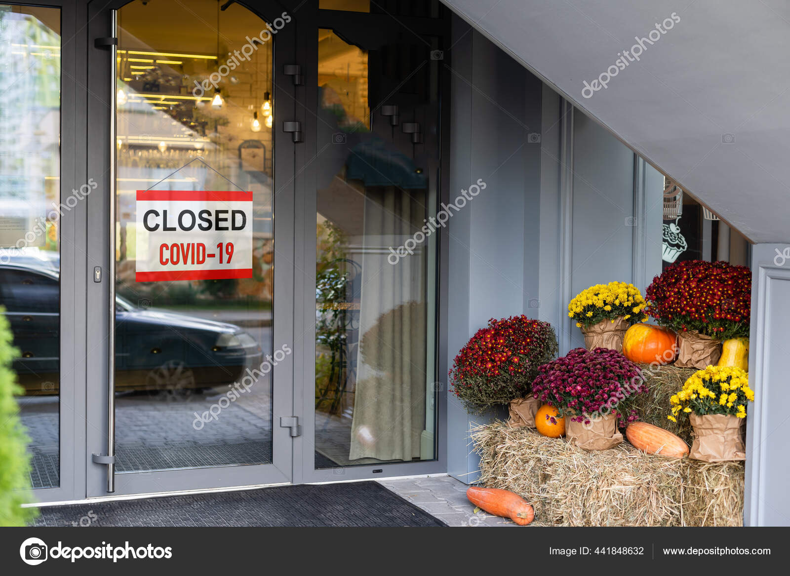 Close-up on a red closed sign in the window of a shop displaying the message Closed due to Covid ...