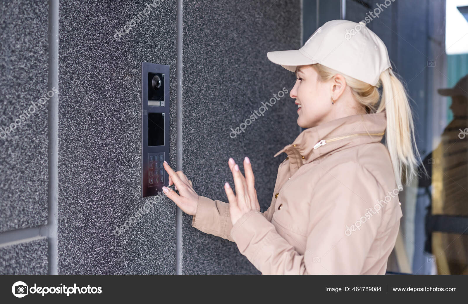 Close up the female hand presses the doorphone button. The girl is calling the intercom. Means ...