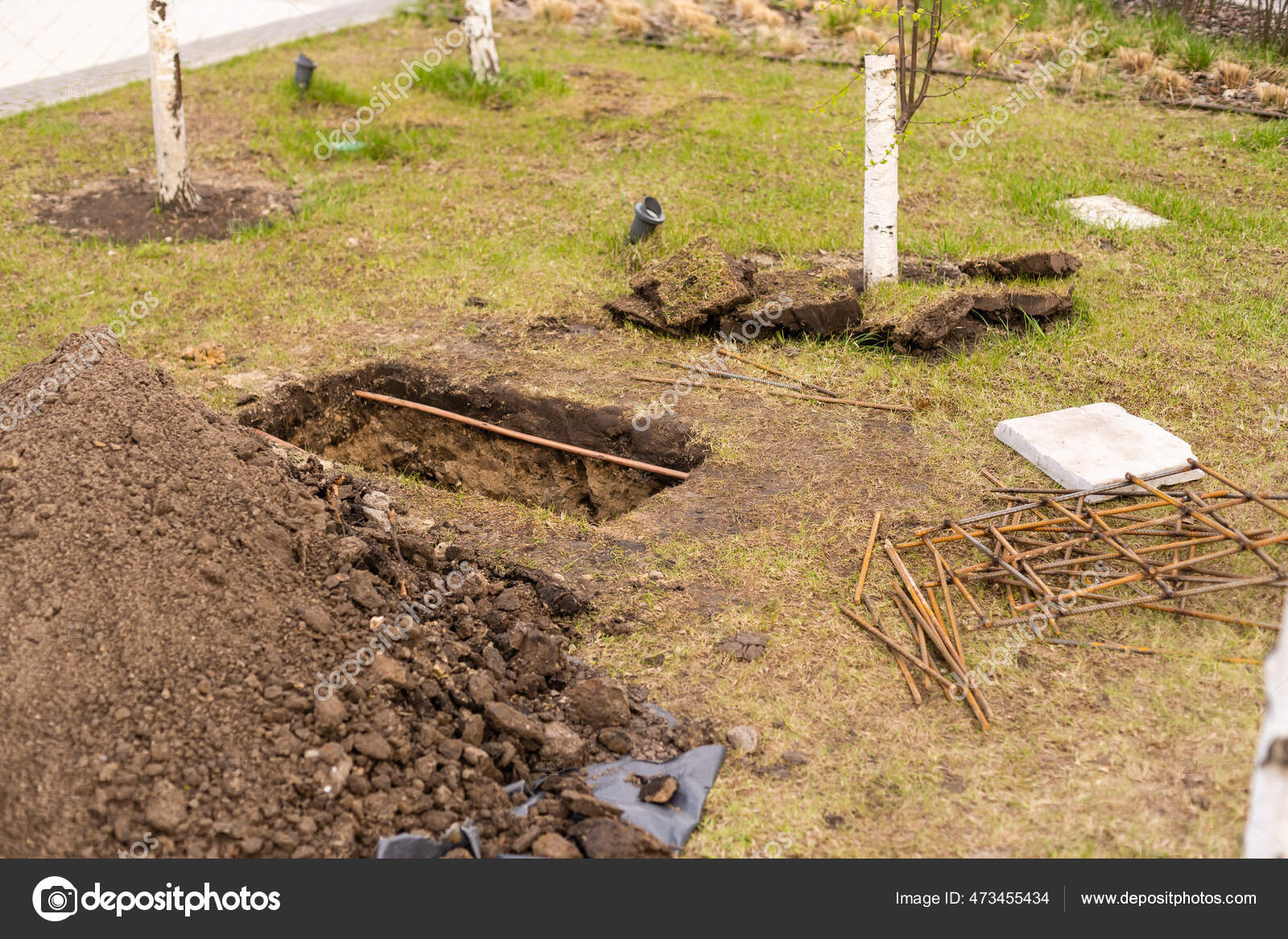 A landscape worker digging a trench during an irrigation system ...