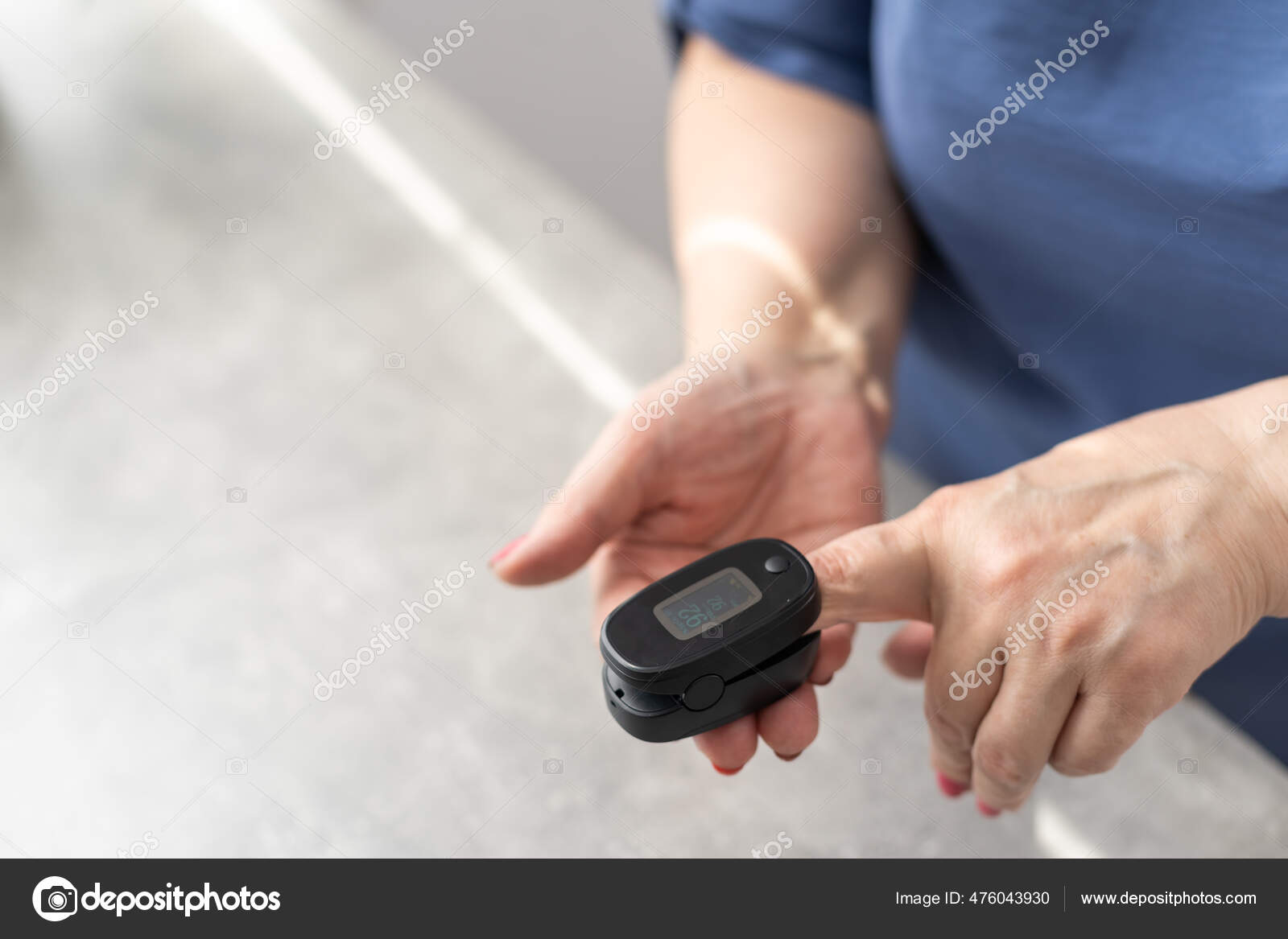 Middle-aged grey-haired woman feels unwell, measuring blood pressure ...