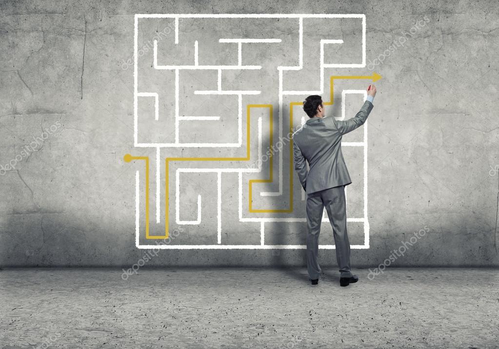 Empresario dibujando laberinto en la pared 2024