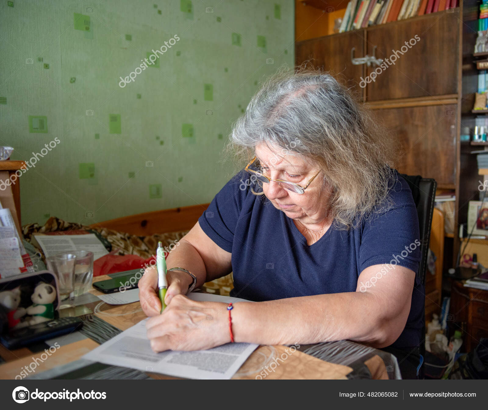Elderly Lady Signing Paperwork in her Bedroom Stock Photo by ©vilevi ...