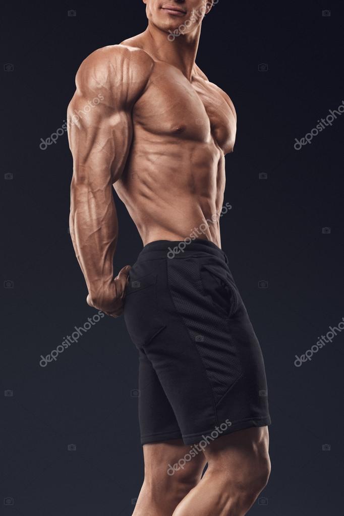 Fuerte y guapo joven culturista demostrar su torso muscular 2023