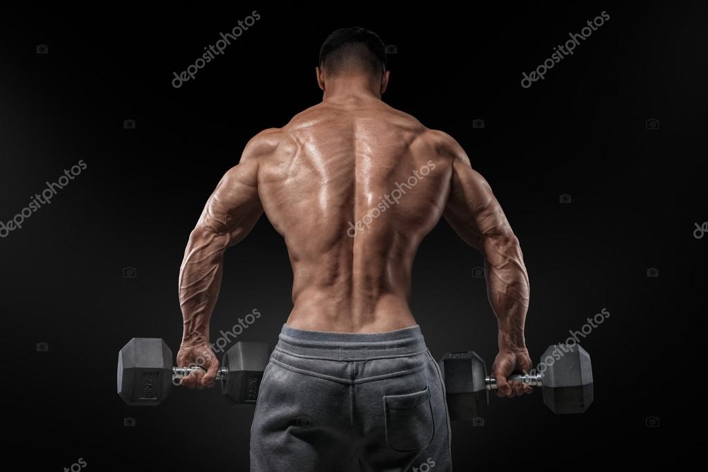 Strong bodybuilder doing exercises with dumbbells turned back Stock ...