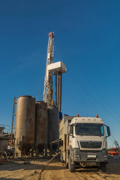 Drilling rig with well cementing equipment in the foreground ...