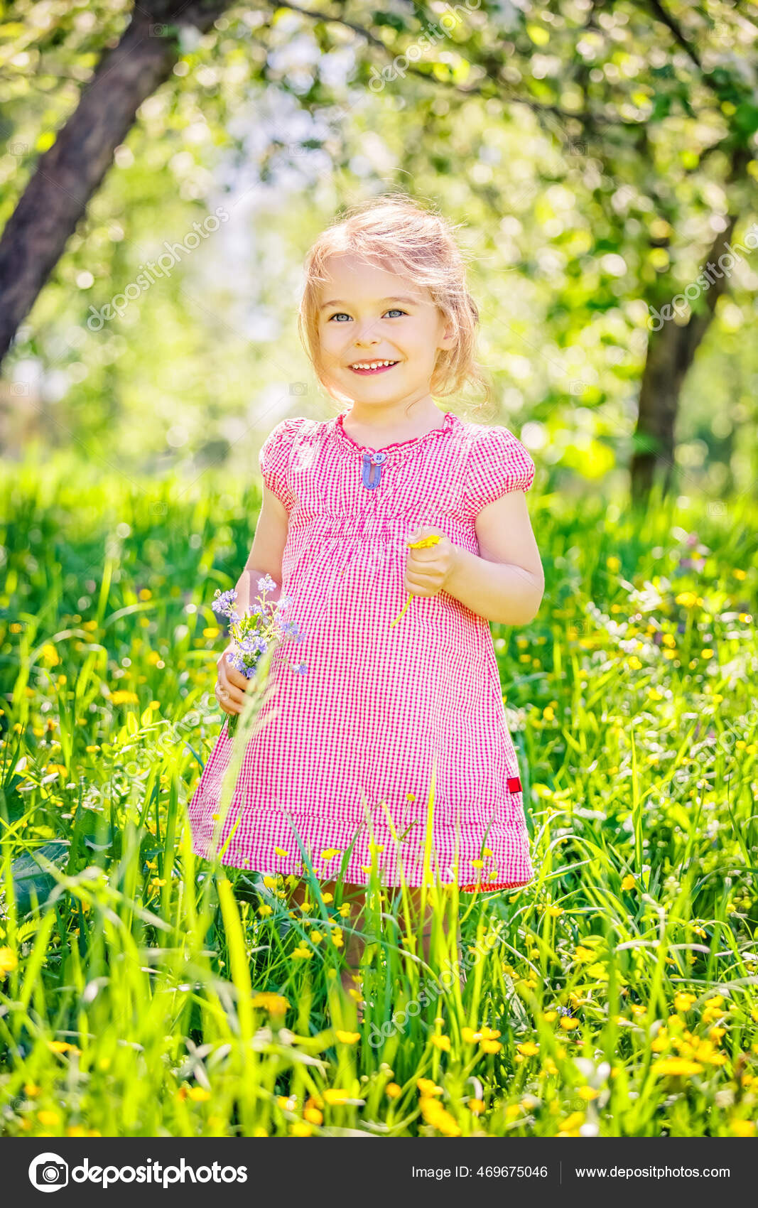 Happy little girl in spring garden Stock Photo by ©sborisov 469675046