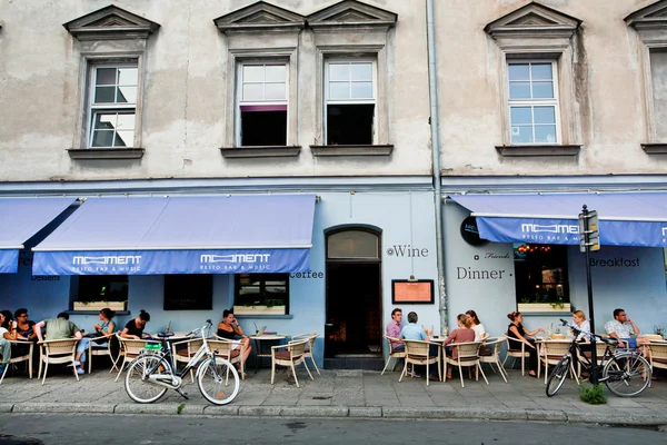 Young people sitting around the tables of restaurant - Stock Image ...