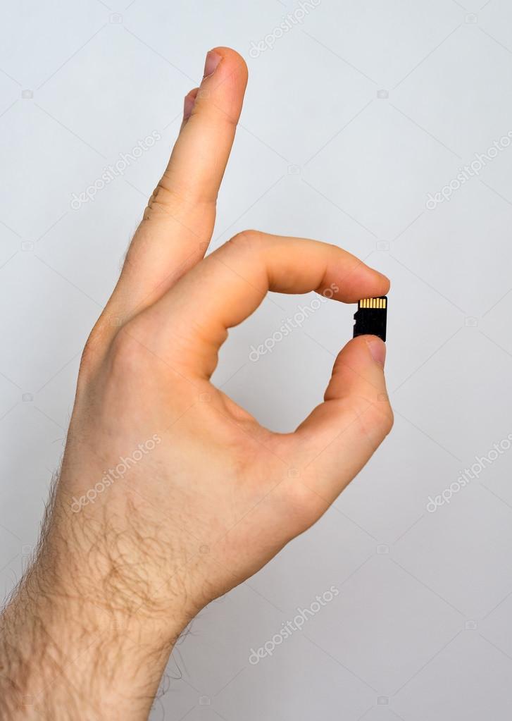 Male hand holding Micro SD card. — Stock Photo © mproduction #68752827
