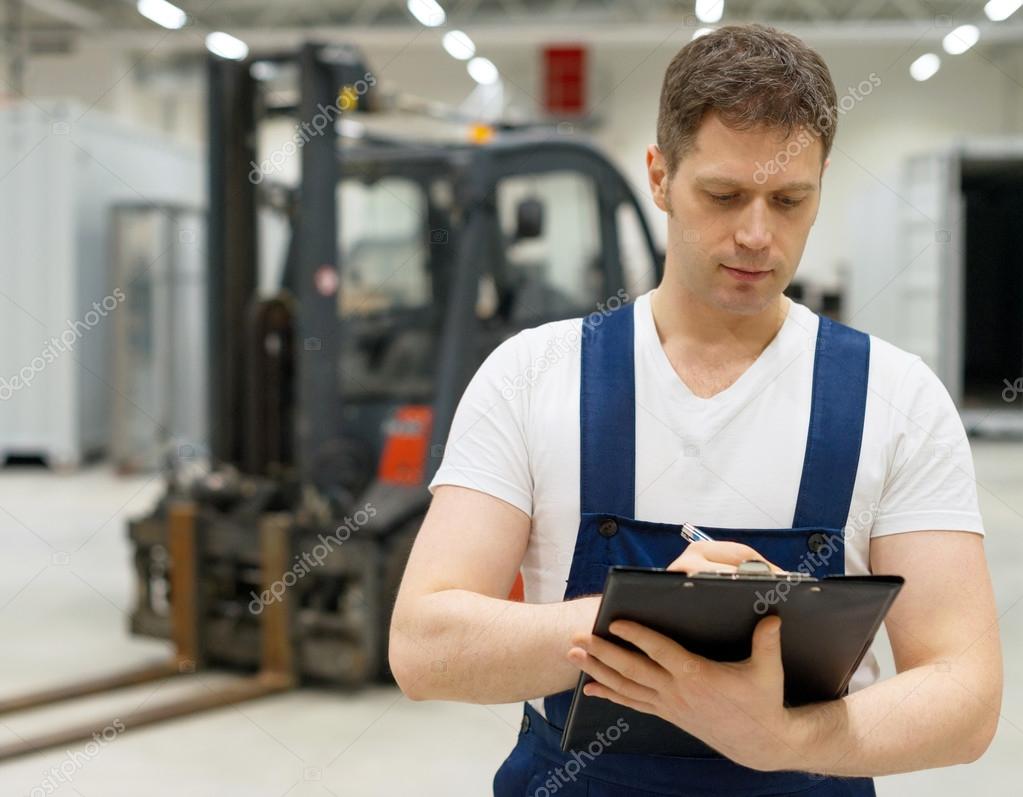 Handsome supervisor with tablet pc at the warehouse. Place for text ...