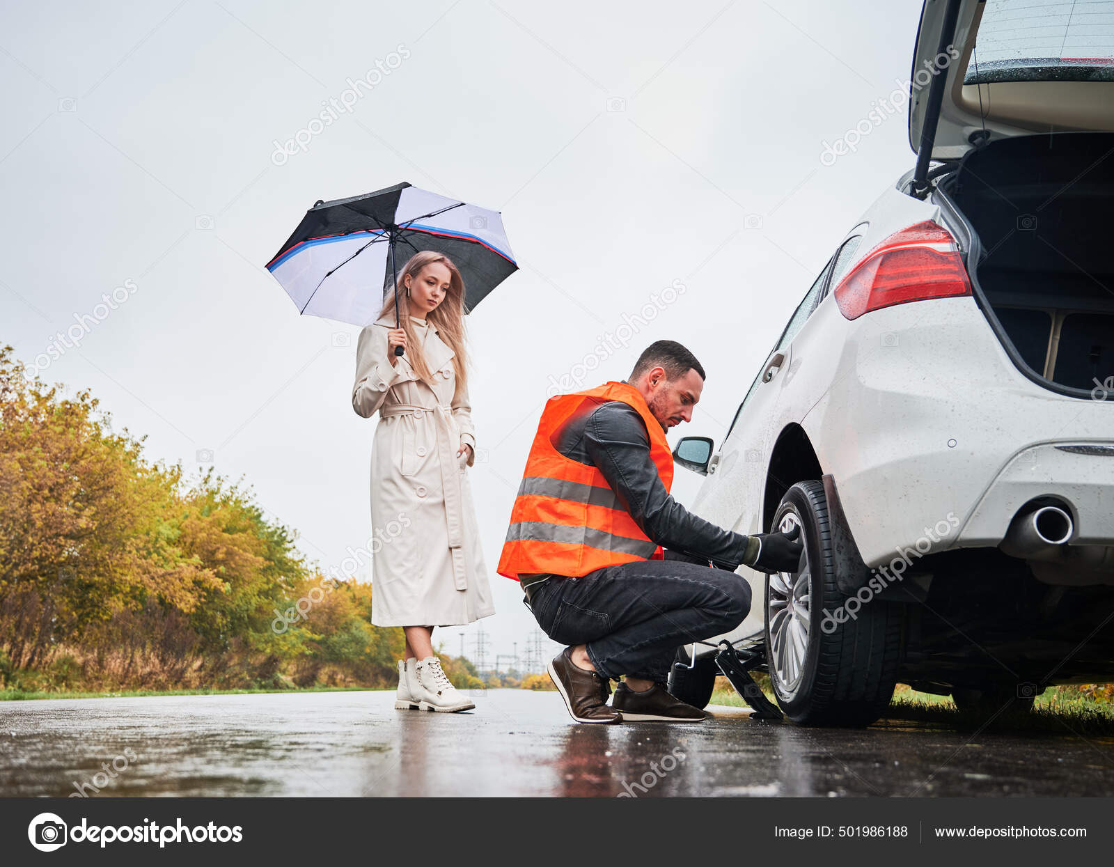 Roadside Assistance Worker Replacing Flat Tire While Beautiful Woman ...