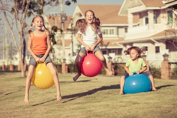 Happy kids playing with inflatable balls on the lawn Stock Photo by ...