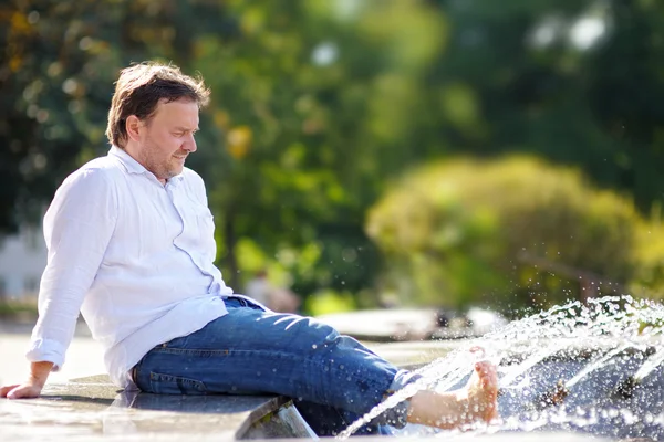 Man having fun in a city fountain - Stock Image - Everypixel