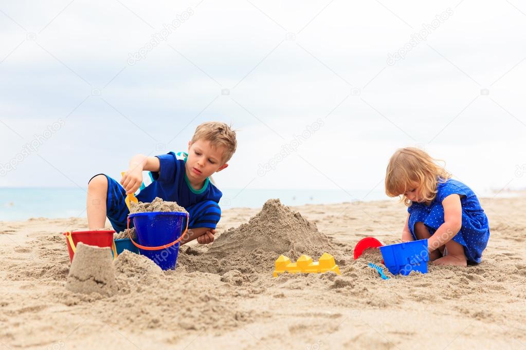 Kids play with sand on summer beach Stock Photo by ©Nadezhda1906 108681834