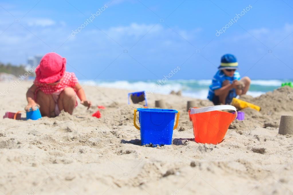 Kids play with sand on beach Stock Photo by ©Nadezhda1906 116378104