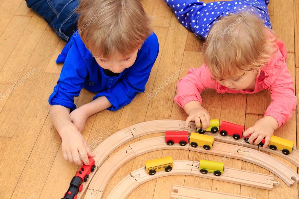 Kids playing with railroad and trains indoor — Stock Photo ...