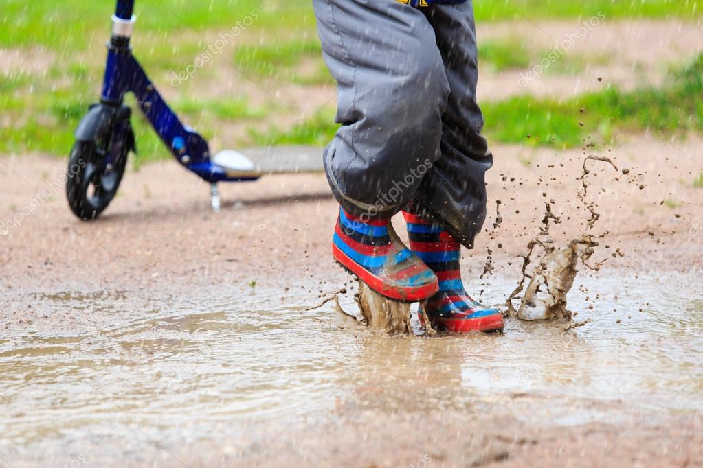 Child playing in water puddle, kids outdoor Stock Photo by ...