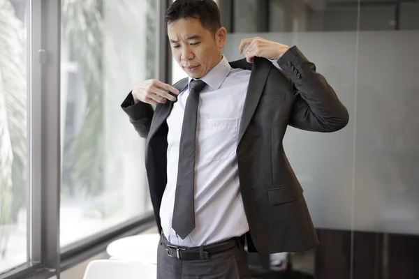 Successful asian man putting on his suit ready for meeting - Stock ...
